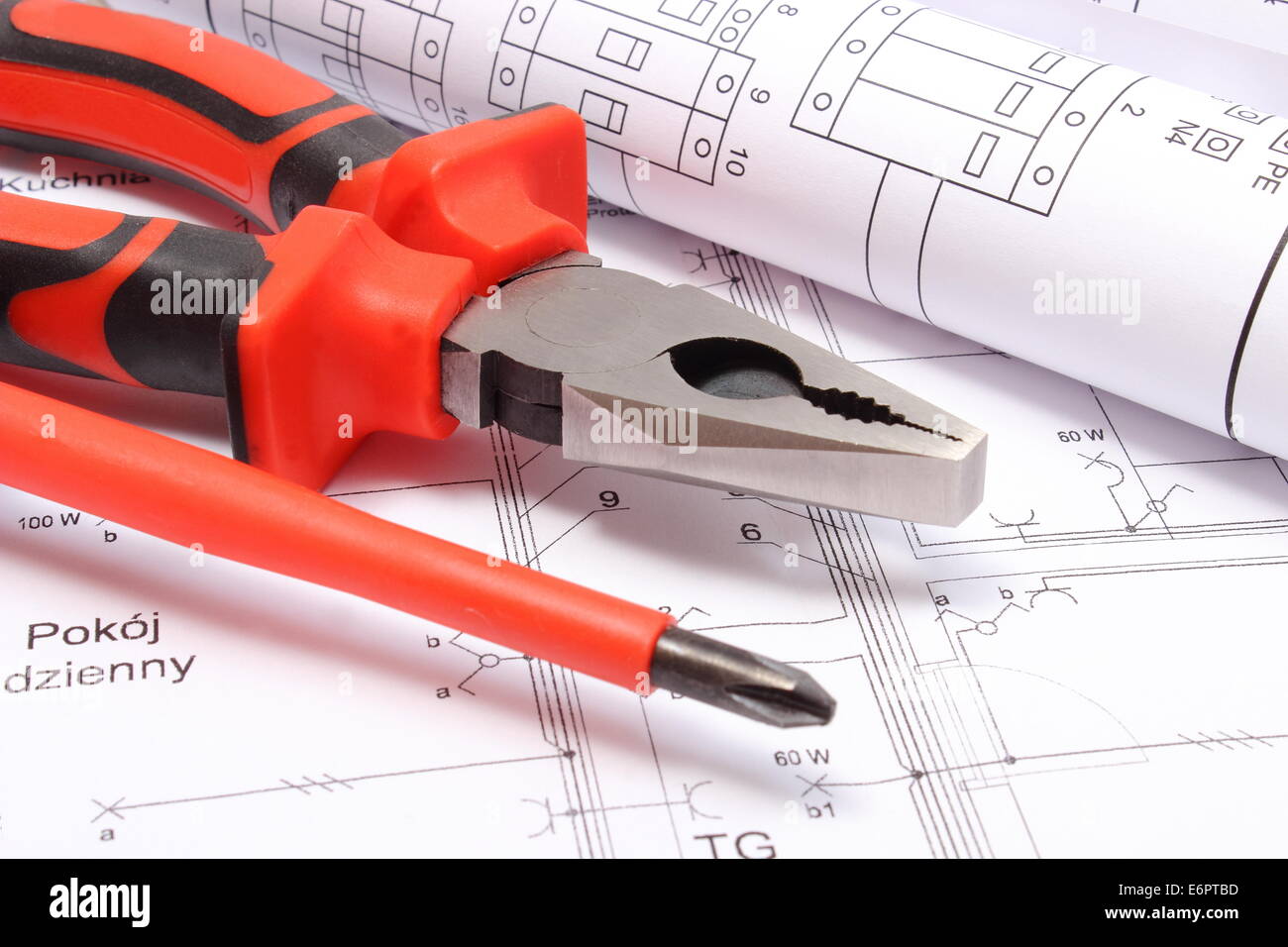Rolled electrical diagrams with work tools lying on construction ...