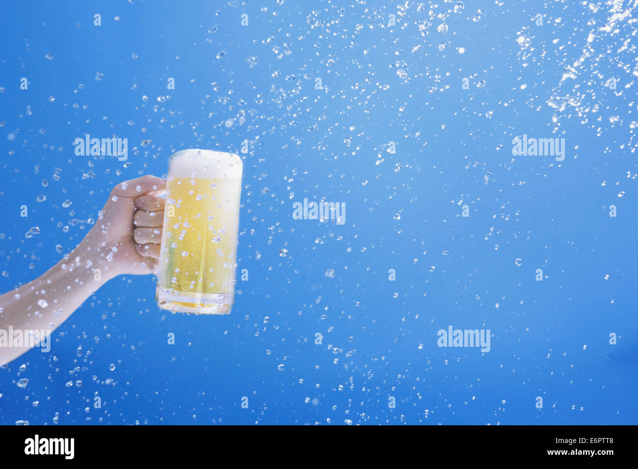 Man holding draft beer and water splash Stock Photo - Alamy