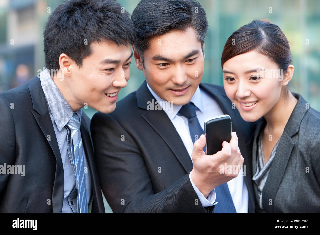 Business people looking at cellphone Stock Photo - Alamy