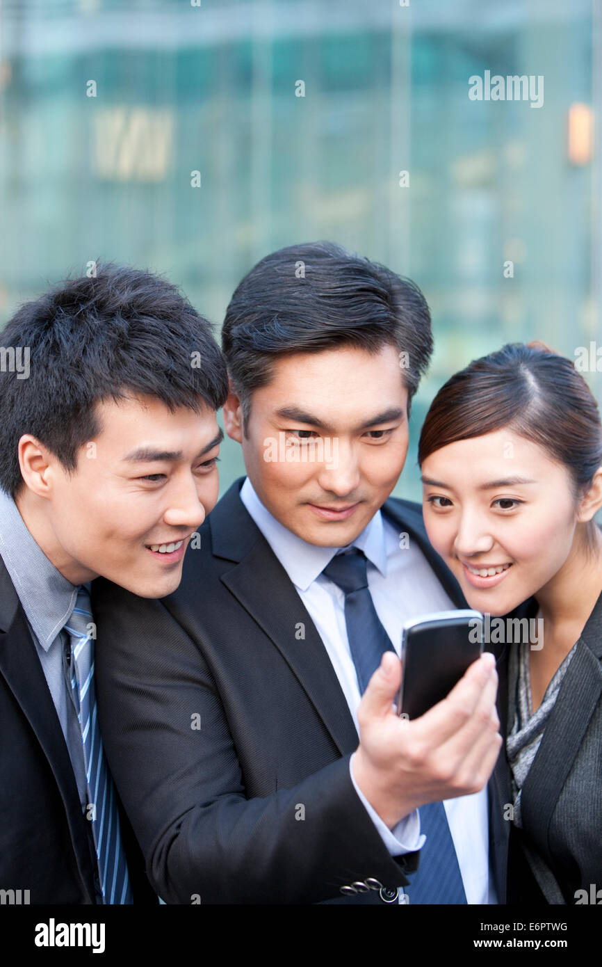 Business people looking at cellphone Stock Photo - Alamy