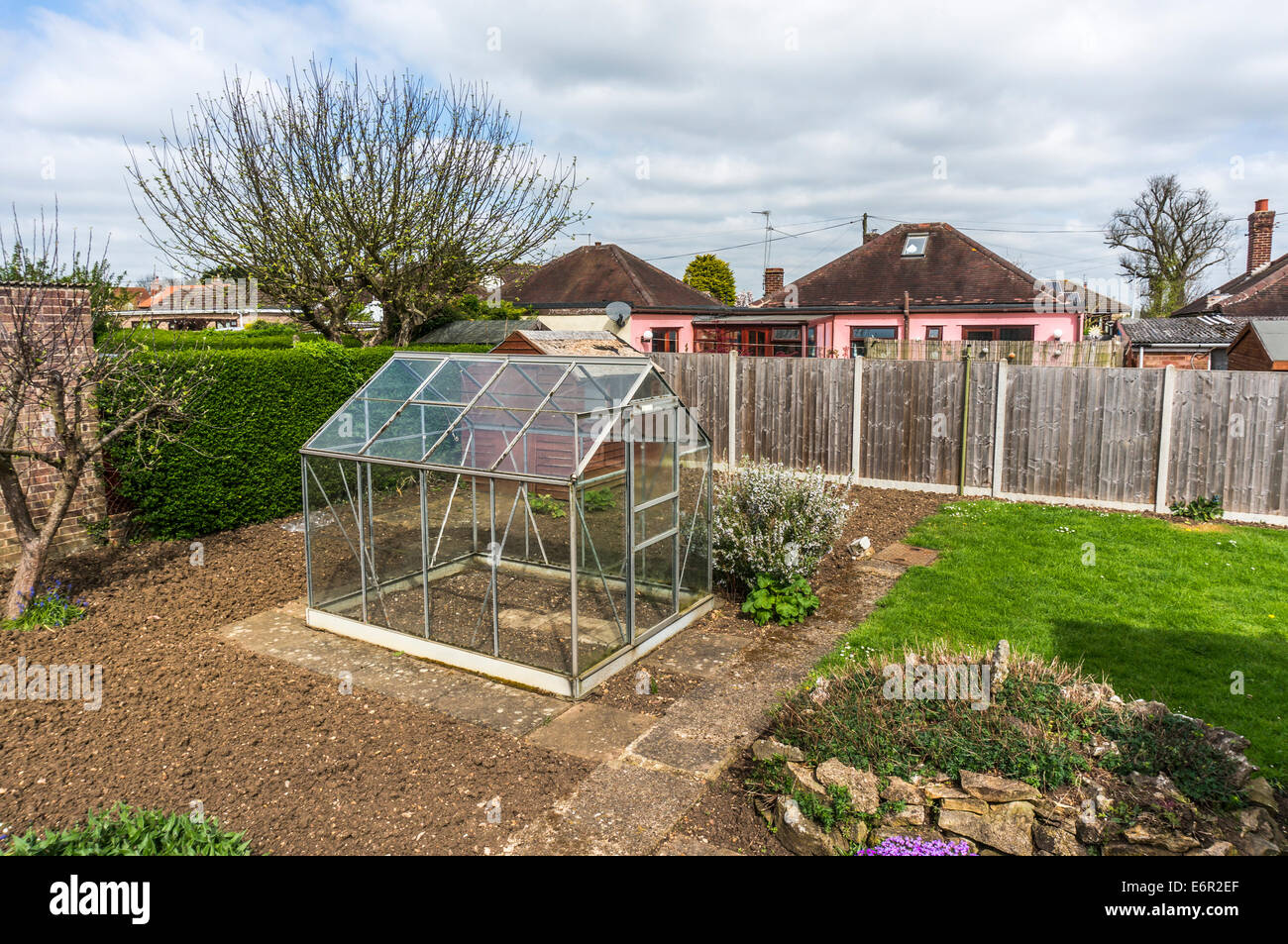 Empty green house and vegetable plot ready for growing in a back garden ...