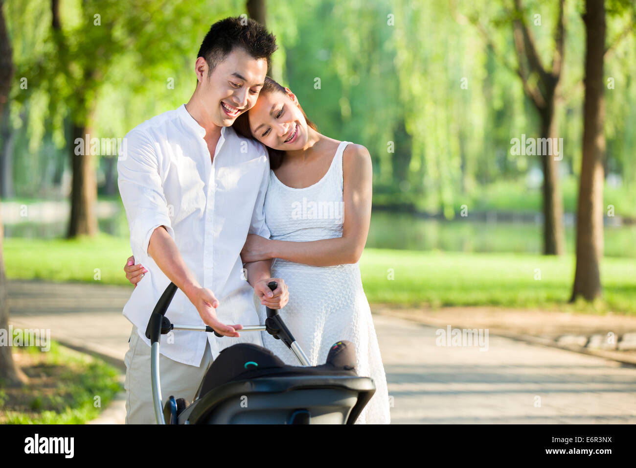 Young couple with their baby in pram Stock Photo - Alamy