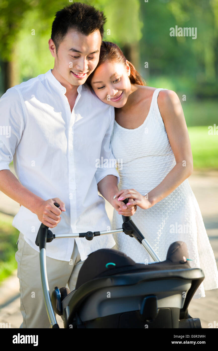 Young couple with their baby in pram Stock Photo - Alamy