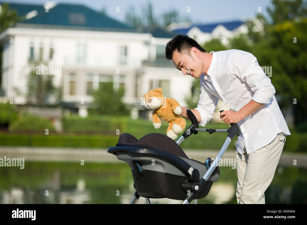 Young man playing with his baby in pram Stock Photo - Alamy