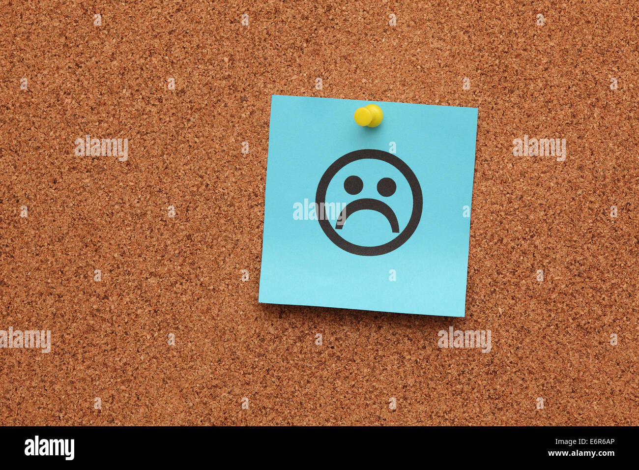 Blue paper with sad face on cork board (bulletin board Stock Photo - Alamy