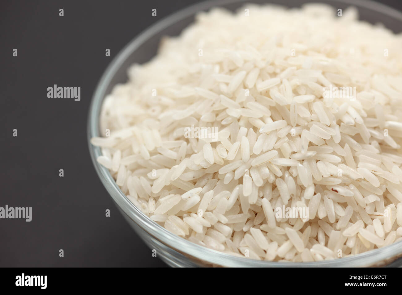 Rice in a glass bowl on black background Stock Photo - Alamy