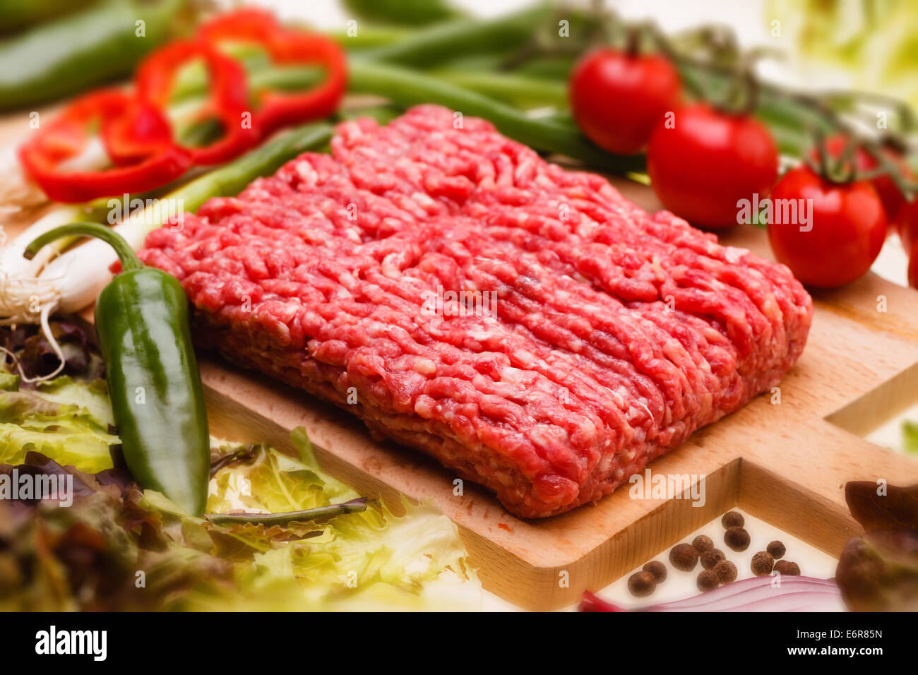 raw minced meat with vegetables on wooden board, selective focus Stock ...