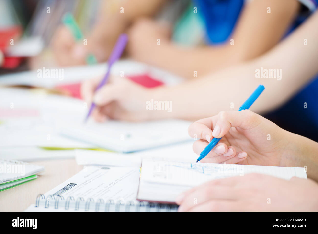 Students writing in classroom, close up Stock Photo - Alamy