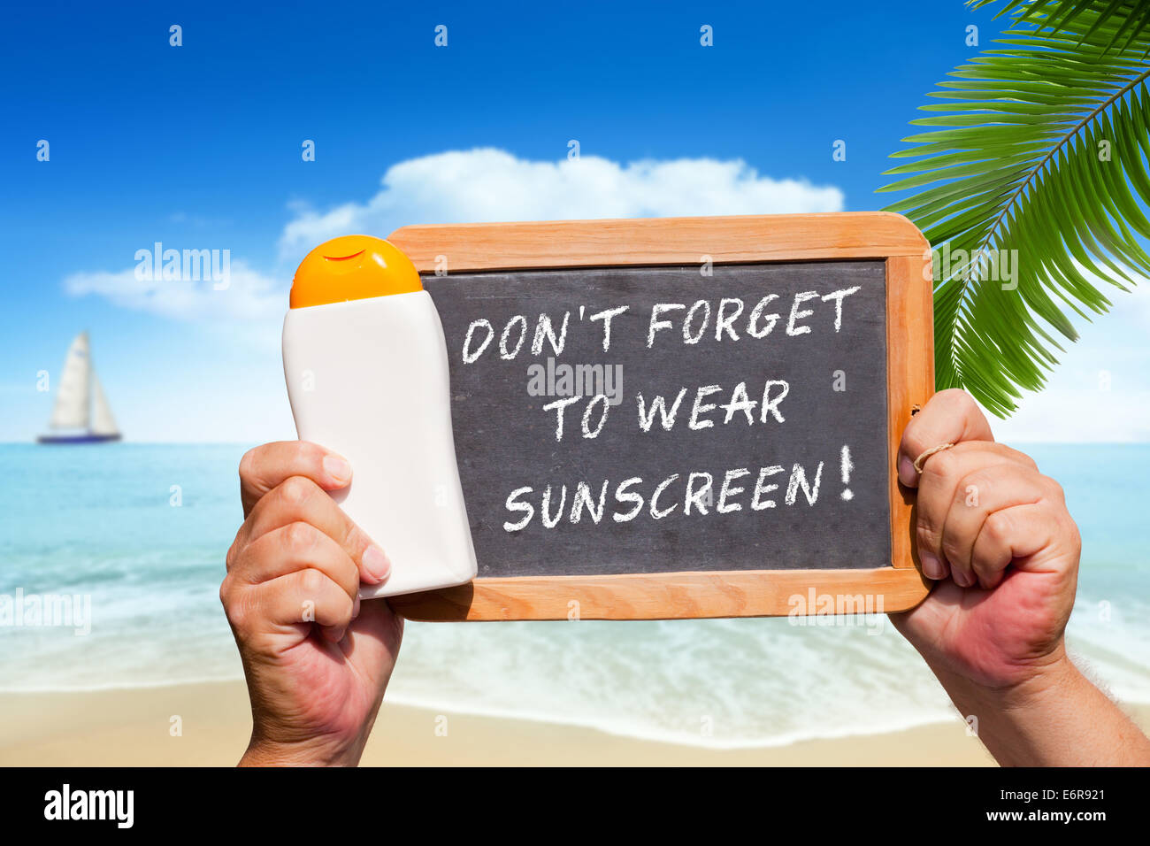 Human Hands hold a bottle sunscreen and a slate blackboard with text ...