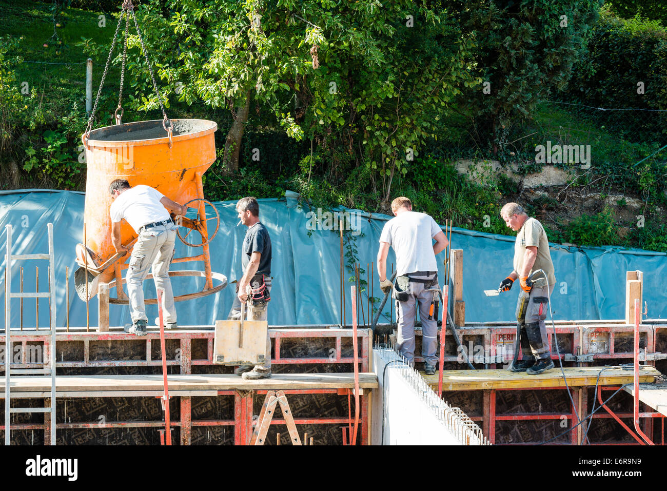 workers at construction site pouring concrete in form Stock Photo - Alamy