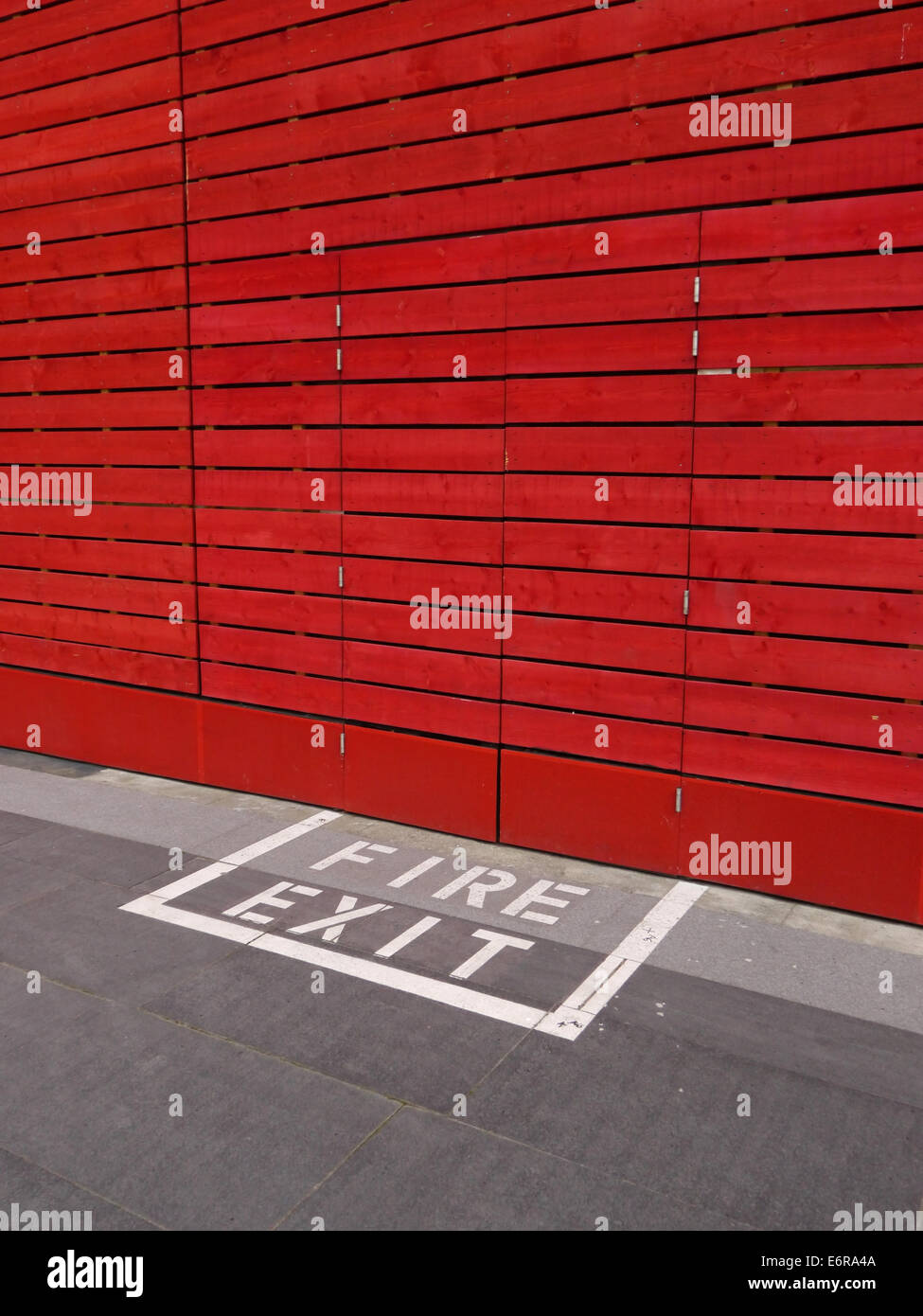A camouflaged Fire Exit in a red wooden wall Stock Photo - Alamy