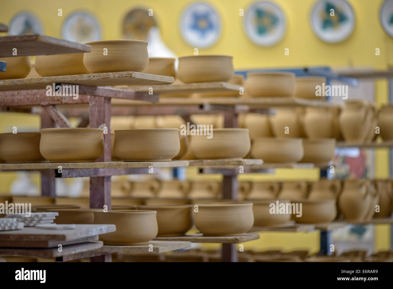 Shelves with clay dishware in pottery workshop Stock Photo - Alamy