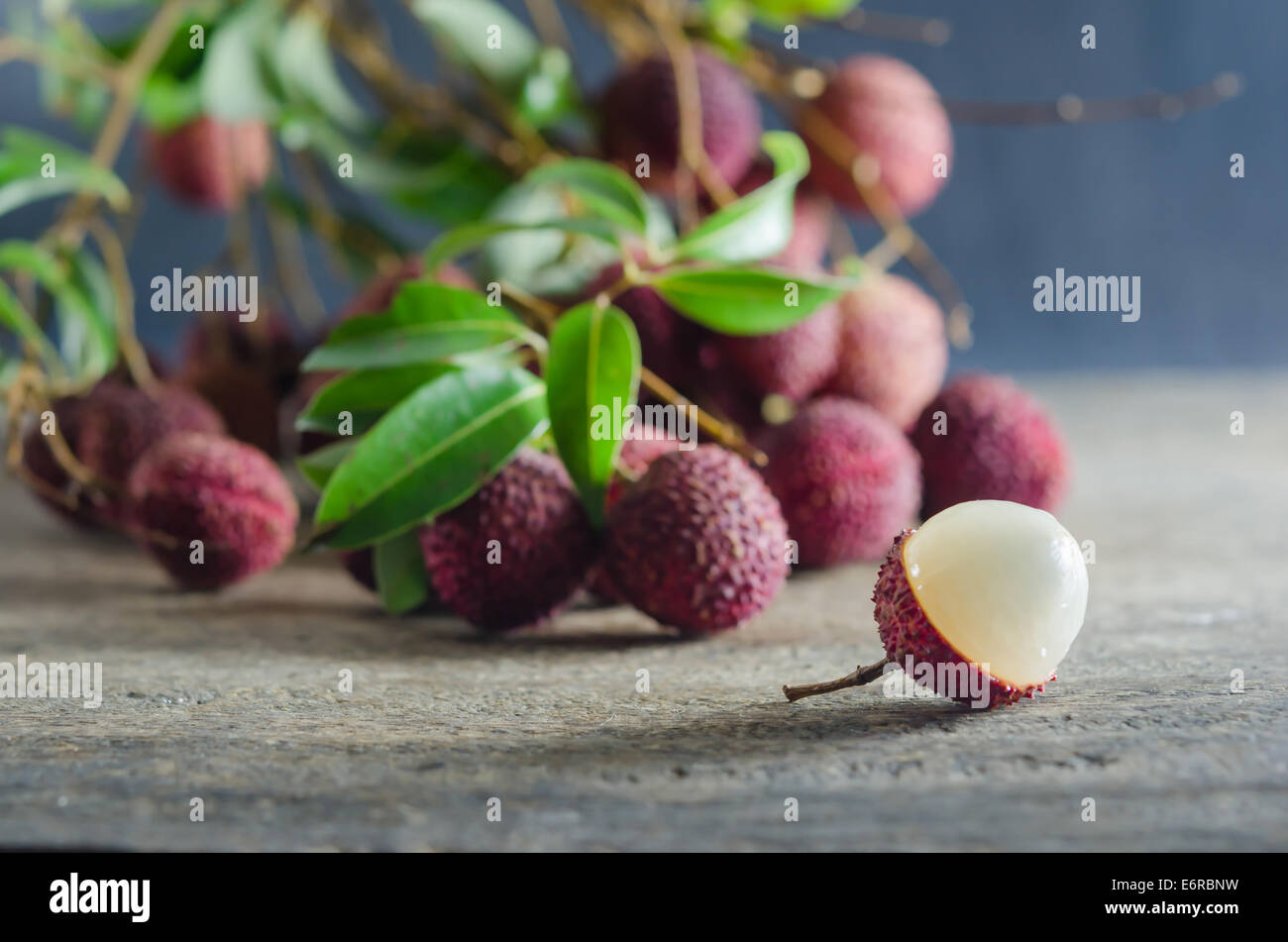 Lychee with leaves on a wooden table Stock Photo - Alamy