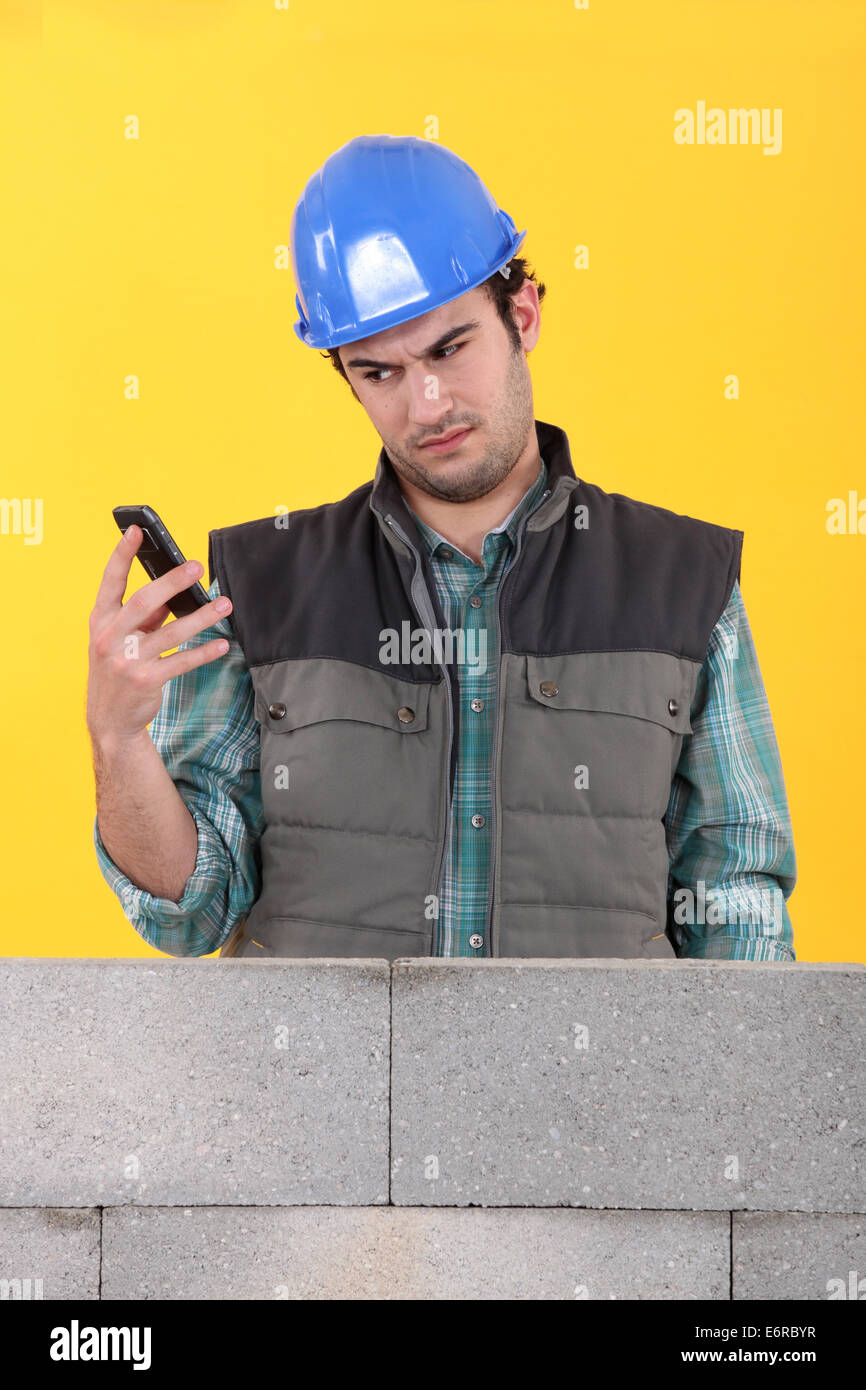 Builder reading a text message Stock Photo - Alamy