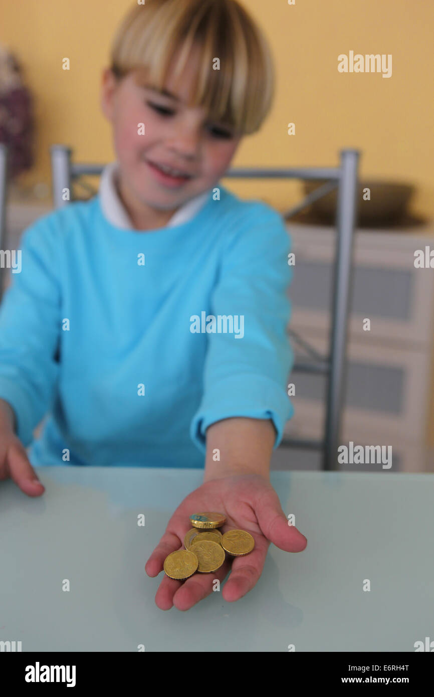 Little boy holding coins Stock Photo - Alamy