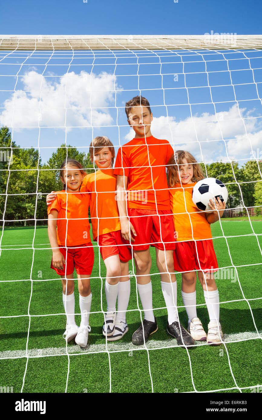 Kids stand in line with football behind woodwork Stock Photo - Alamy