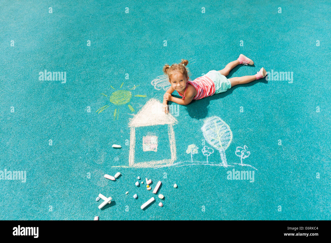 Little girl drawing chalk image on the ground Stock Photo - Alamy