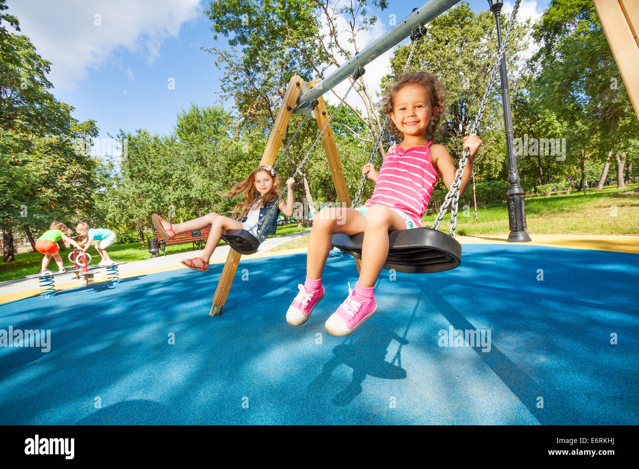 Kids swing on playground Stock Photo - Alamy