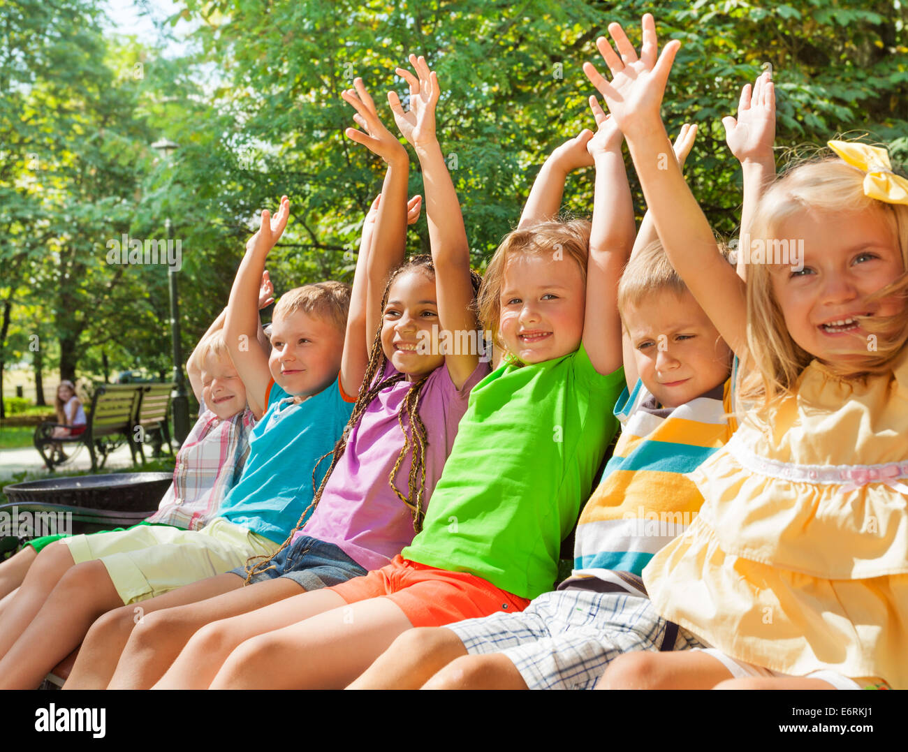 Happy cheering kids lifting hands on the bench Stock Photo - Alamy