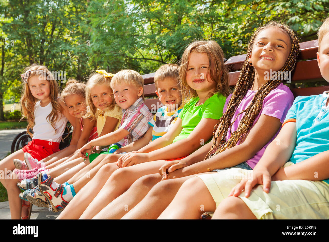 Beautiful little children sit on bench in park Stock Photo - Alamy