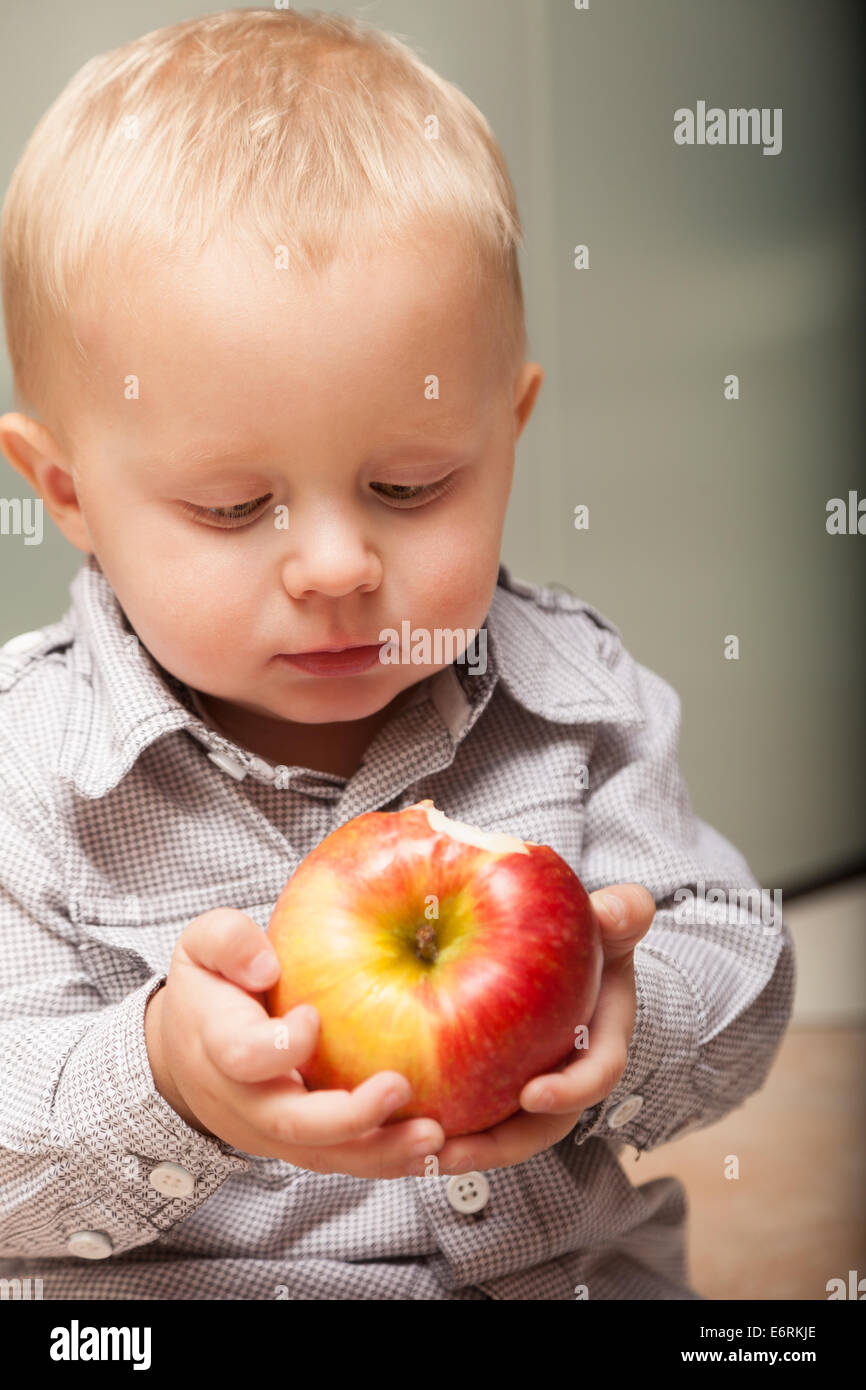 Happy childhood. Portrait of cute little boy child kid eating apple ...