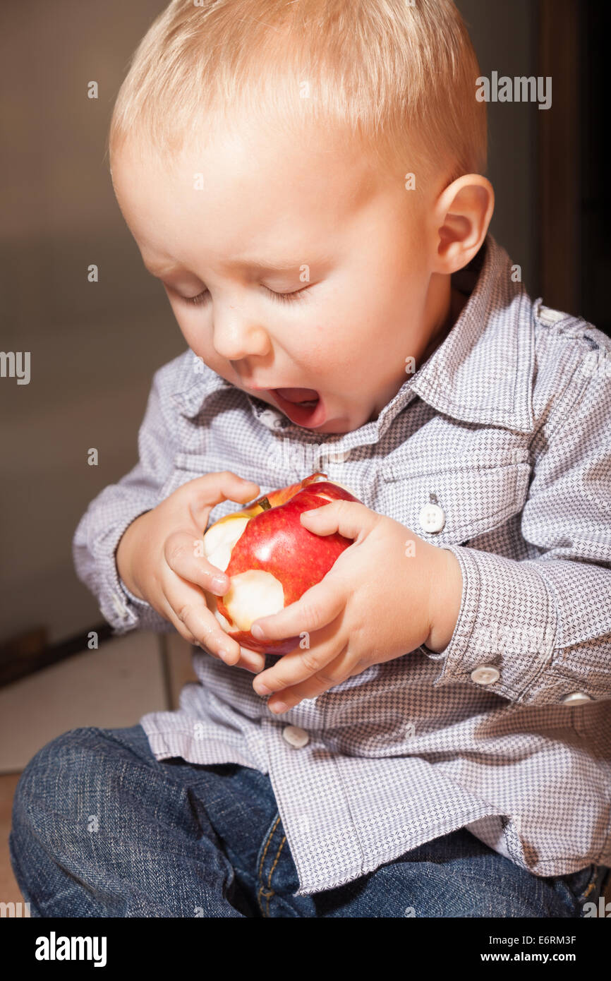 Happy childhood. Portrait of cute little boy child kid eating apple ...