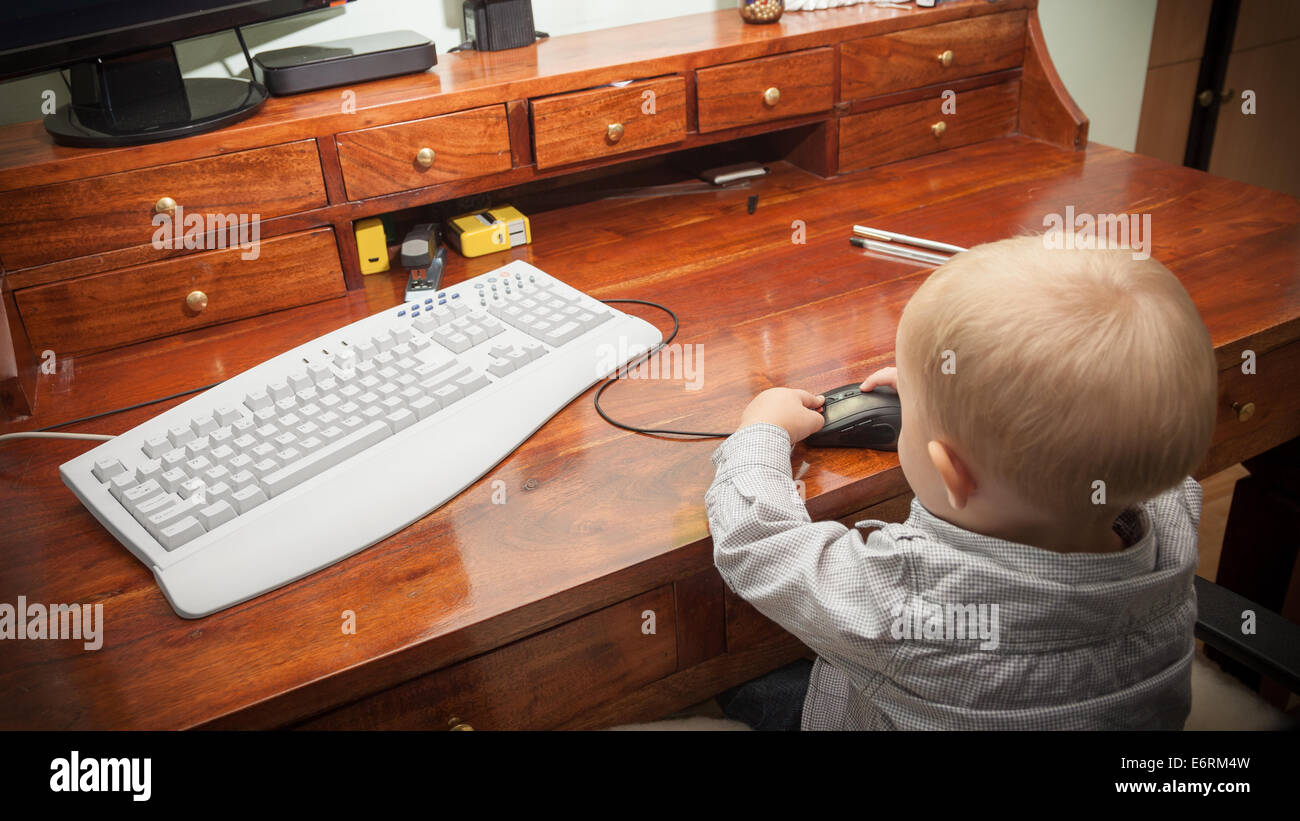 Happy childhood. Smart little boy child kid playing on the desktop ...