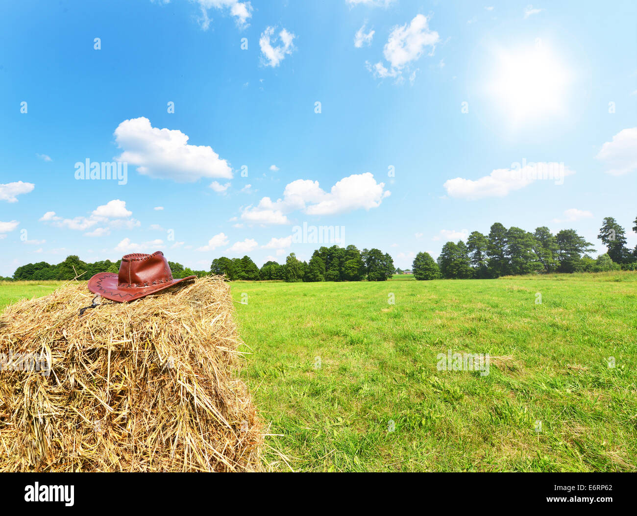 Summer landscape with cowboy hat on haystack Stock Photo - Alamy