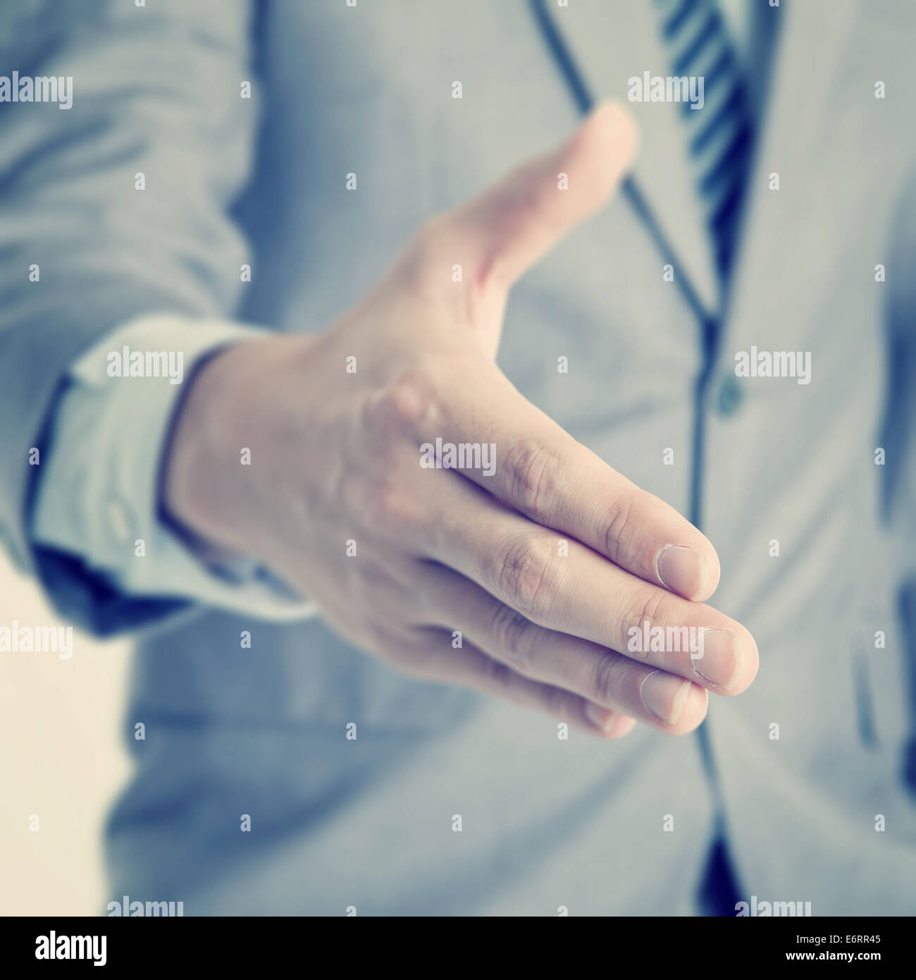 Close up businessman offer hand shake, in vintage retro toned effect ...