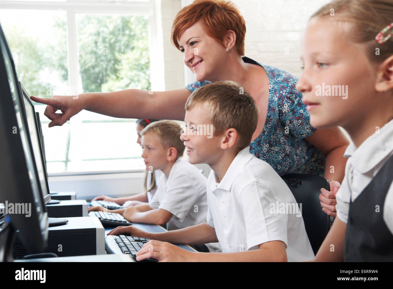 Male Elementary Pupil In Computer Class With Teacher Stock Photo - Alamy