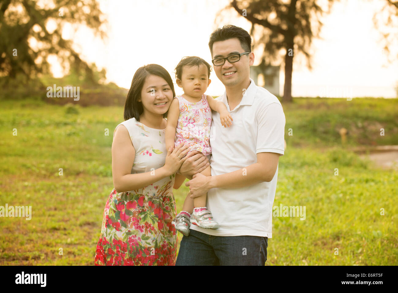 Happy Asian family portrait. Outdoor playing time during summer sunset ...