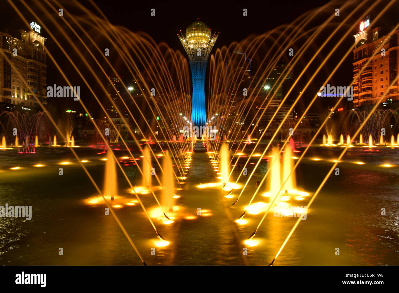 A night view of the Baiterek tower in Astana with a beautiful fountain ...