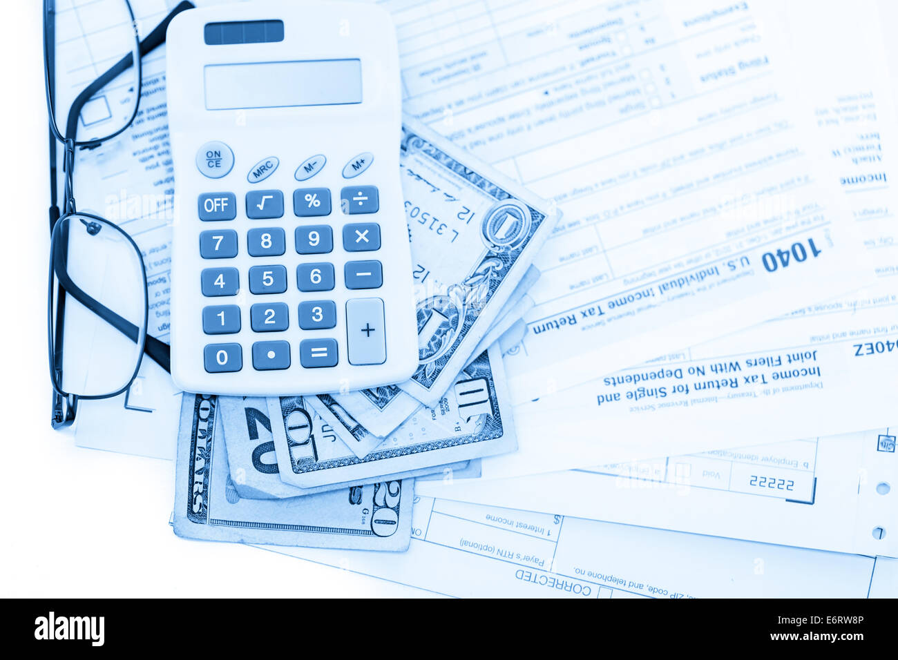 Calculating income tax return with folded cash on a table Stock Photo ...