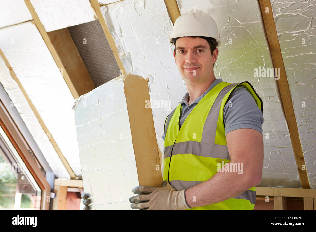 Builder Fitting Insulation Boards Into Roof Of New House Stock Photo ...