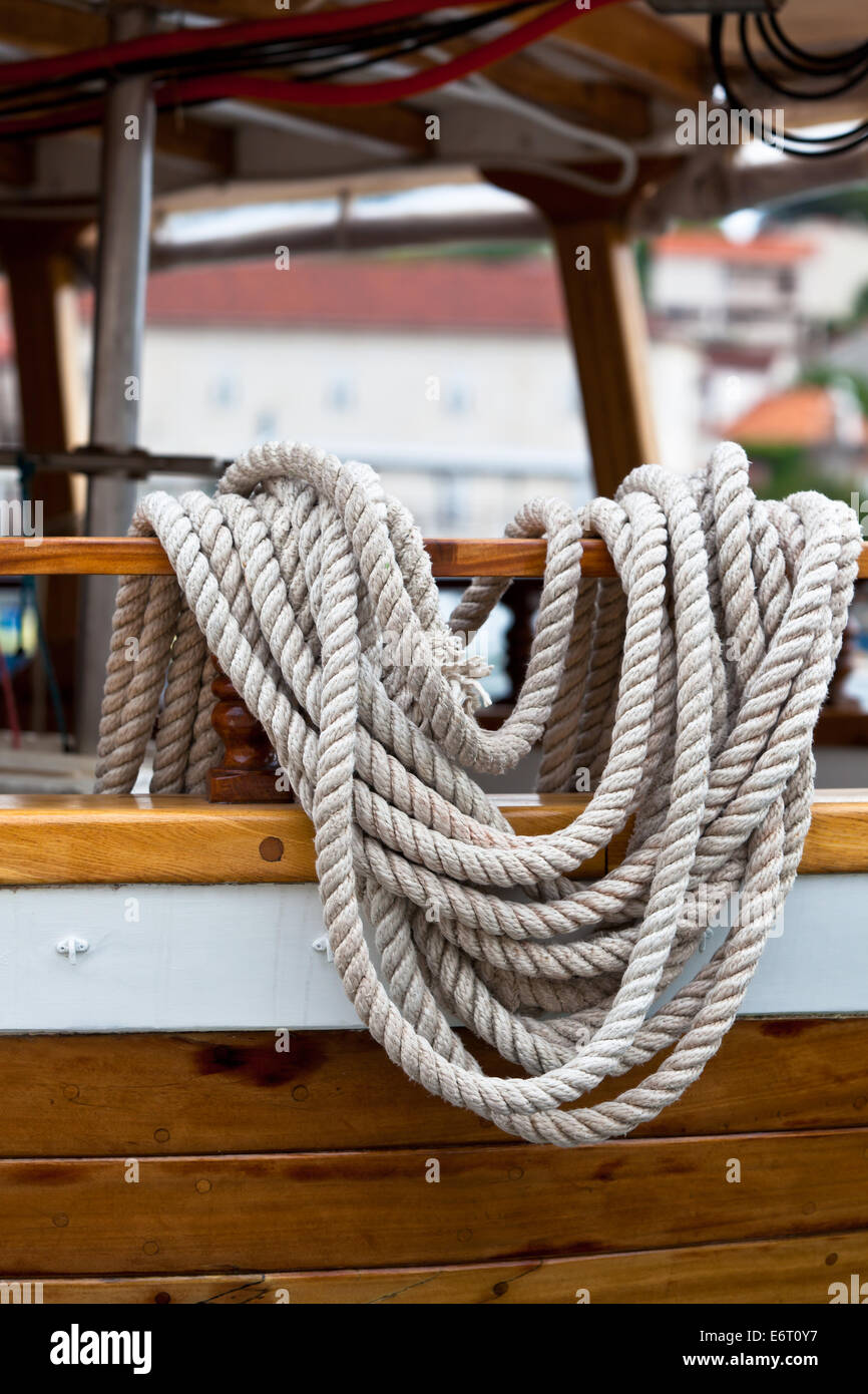 Rope bundle on a wooden boat side. Vertical shot Stock Photo - Alamy