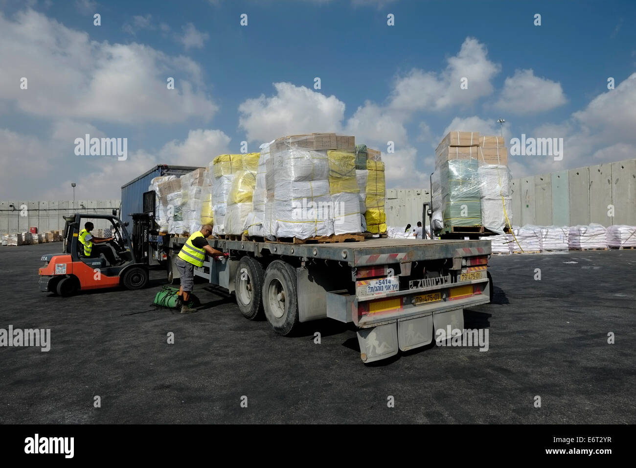 Workers loading goods into trucks on their way to Gaza strip at Kerem ...