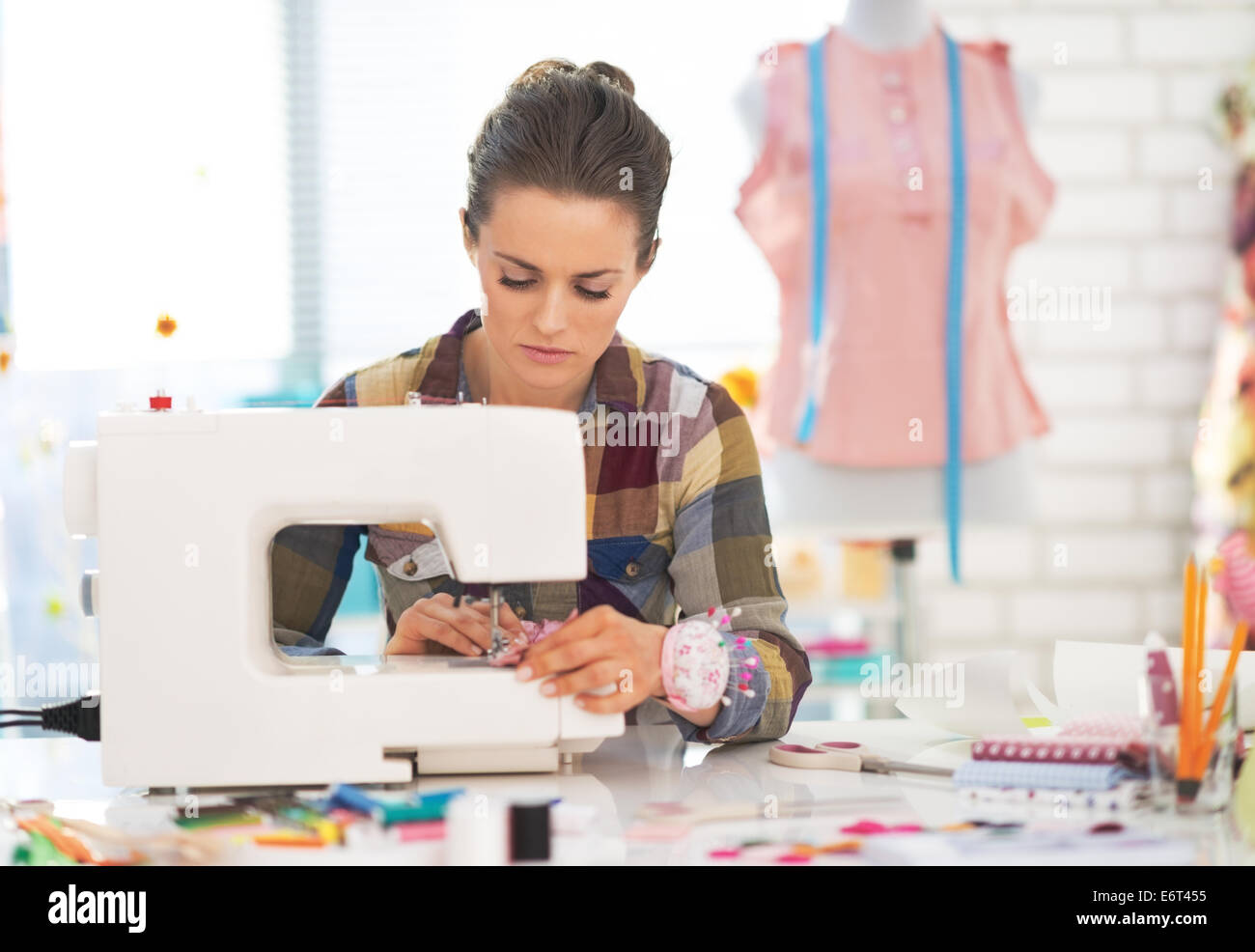 Dressmaker woman working with sewing machine Stock Photo - Alamy