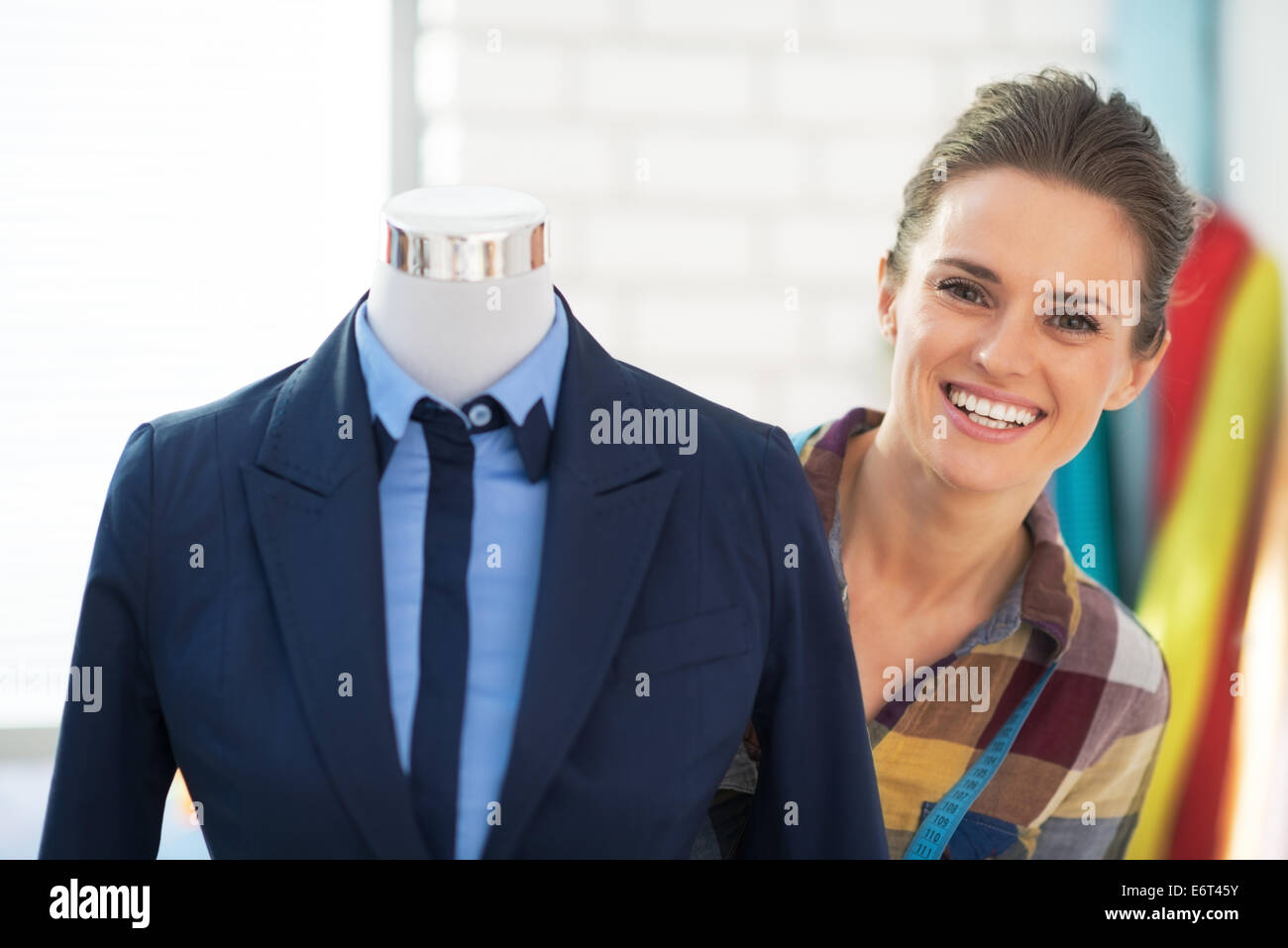 Portrait of tailor woman near business suit Stock Photo - Alamy