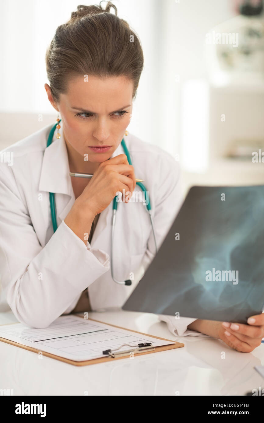 Concerned doctor woman looking on fluorography Stock Photo - Alamy