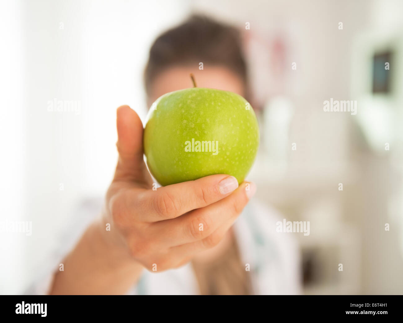 Closeup on doctor woman showing apple in front of face Stock Photo - Alamy