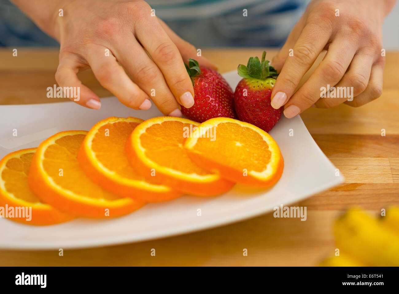 Closeup on young woman making fruits plate Stock Photo - Alamy