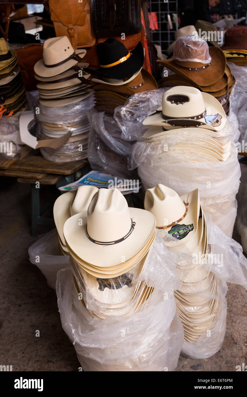 A vendor displays cowboy hats and saddles at the Sunday market in ...