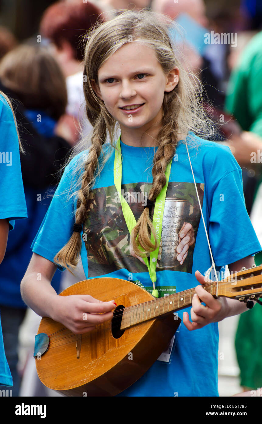 Young girl playing mandolin with a school singing group promoting a ...