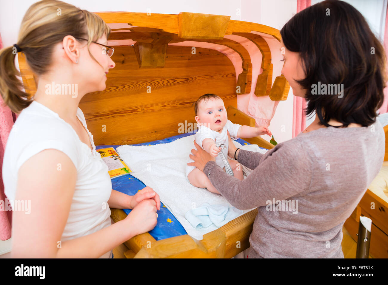 Midwife examining newborn baby at postnatal care in practice Stock ...