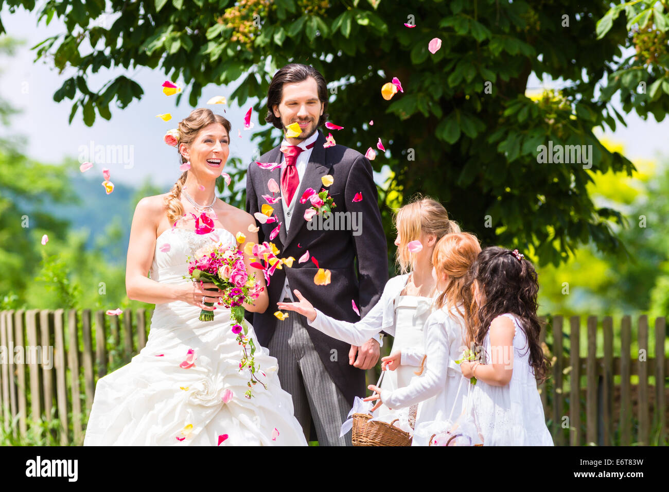 Wedding couple bride and groom with flower children or bridesmaid in ...