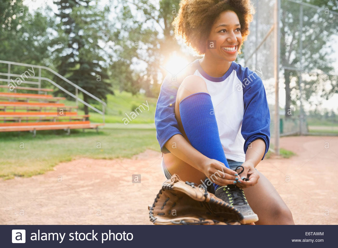 Baseball player tying shoe on field Stock Photo - Alamy