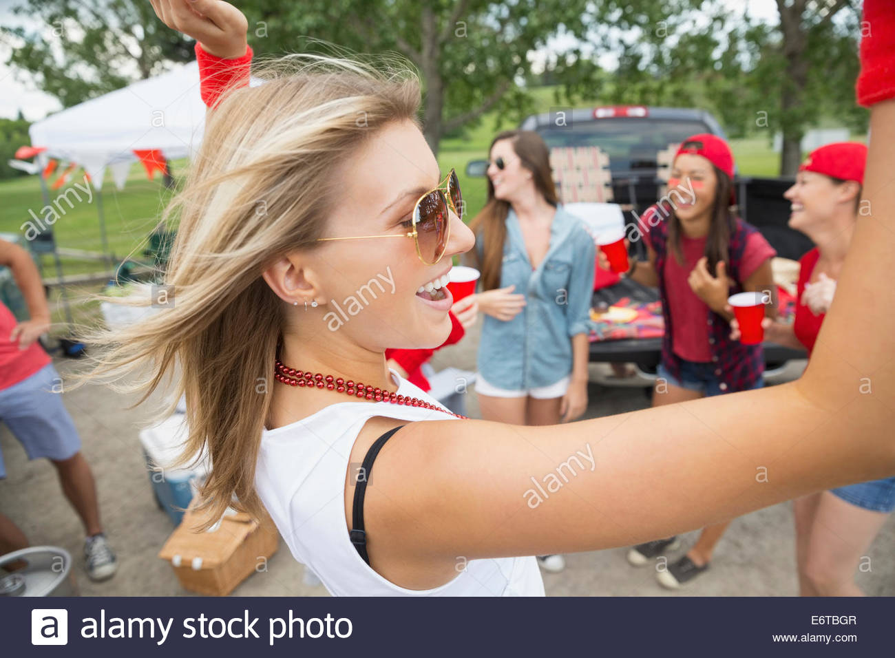 Woman dancing at tailgate barbecue in field Stock Photo - Alamy
