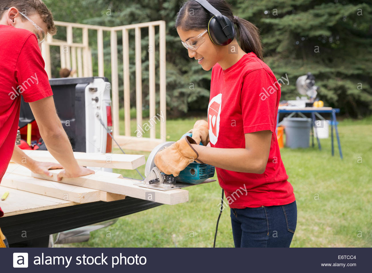 Volunteers using table saw at tailgate Stock Photo - Alamy
