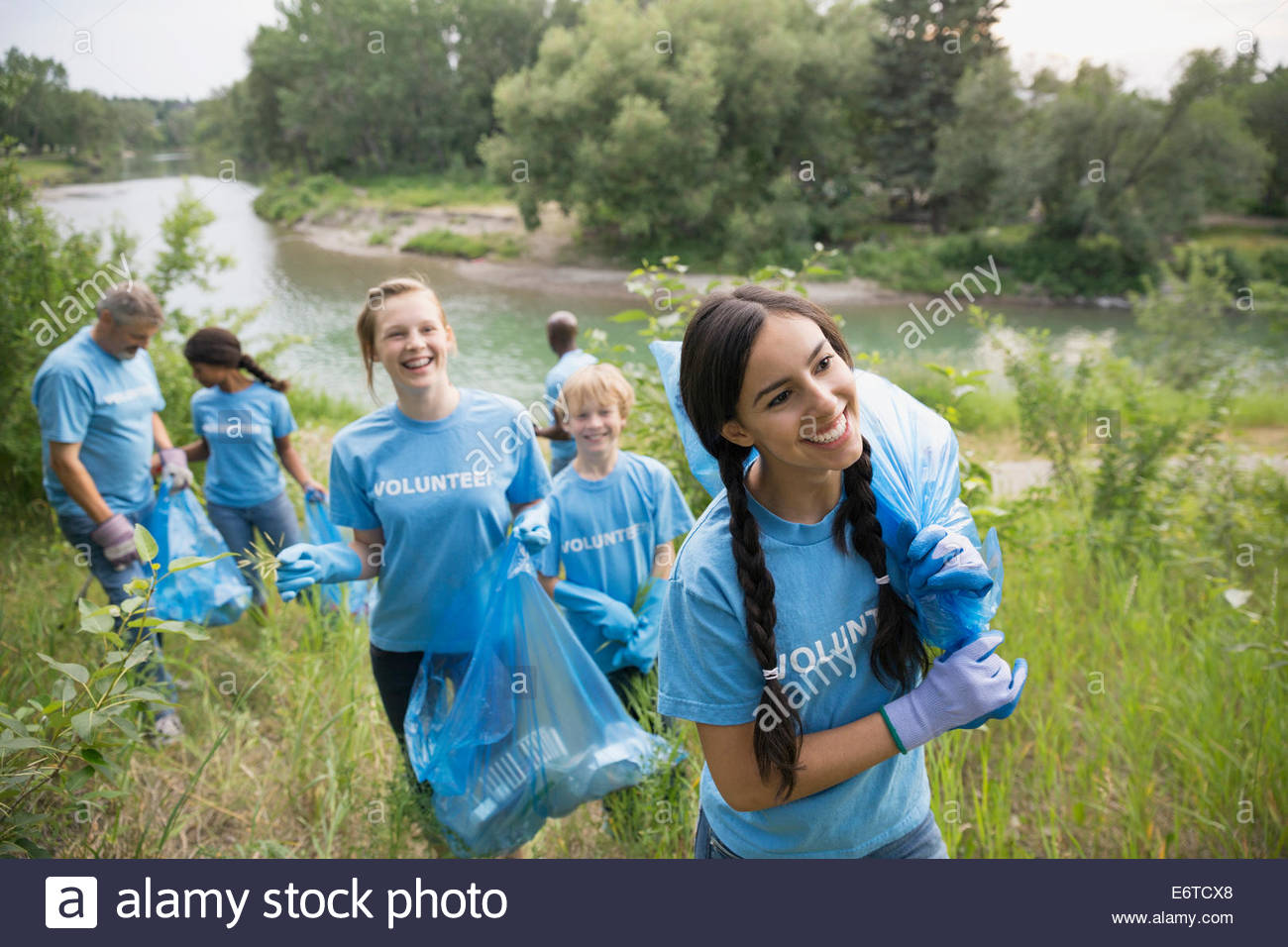 Volunteers carrying garbage bags in field Stock Photo - Alamy