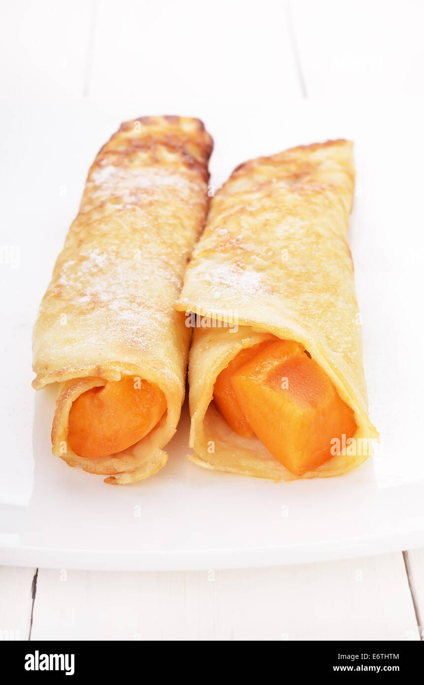 Crepes with apricot slices on white plate Stock Photo - Alamy